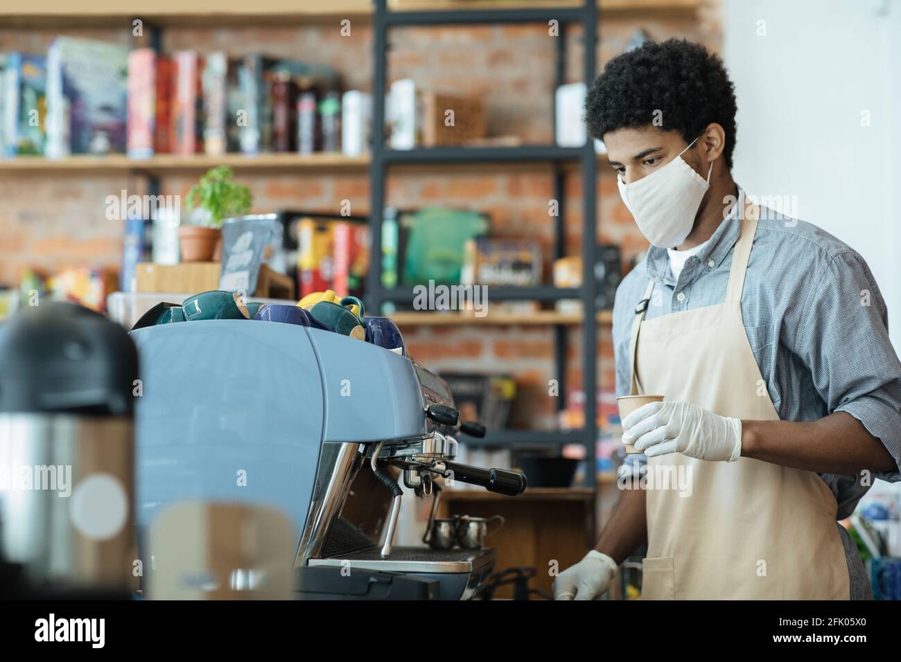 Barista in apron work in coffee shop during COVID-19 and social ...