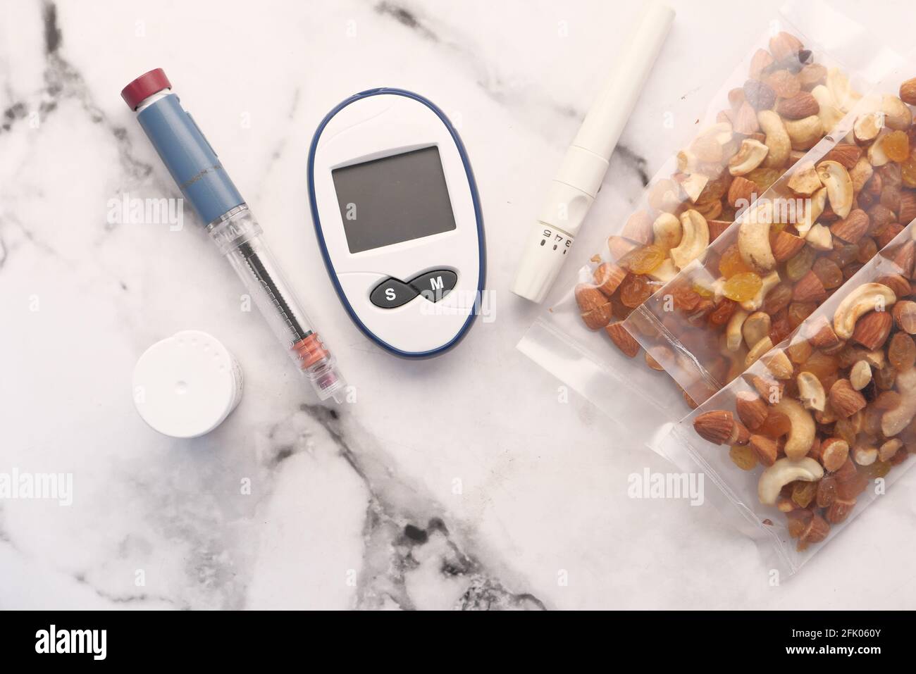 Close up of diabetic measurement tools, insulin and mixed nut on table ...