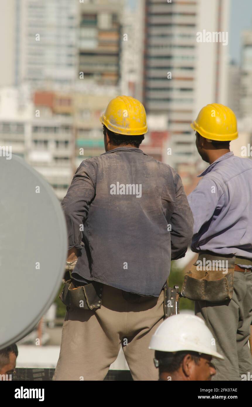 two construction workers planning their working day with work clothes ...