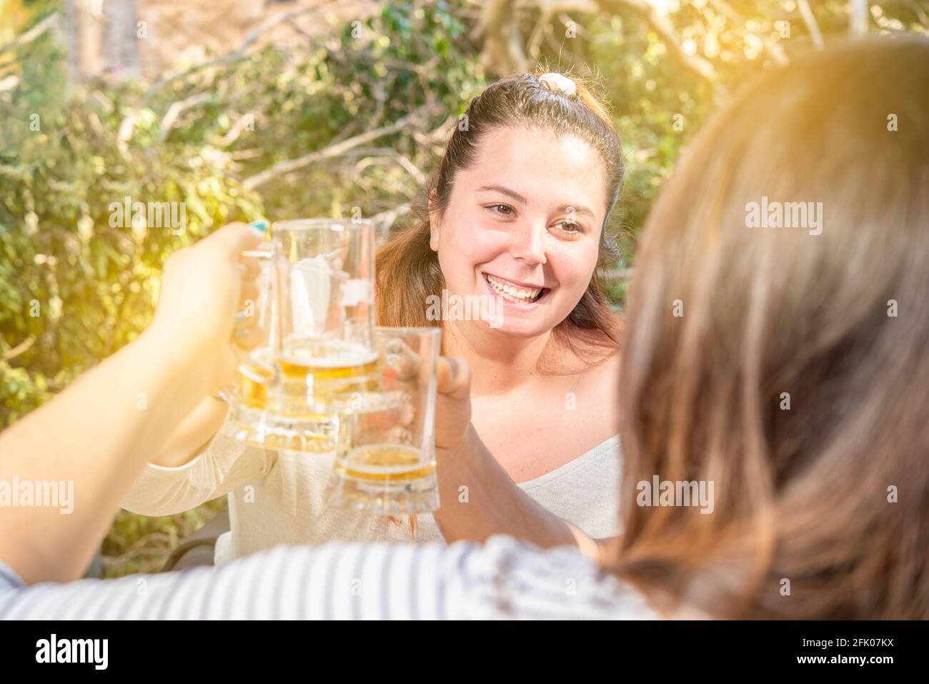 Happy young smiling caucasian woman. Best friends drinking beer and ...