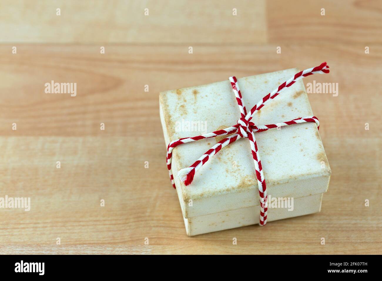Old rusty vintage present gift box with stains tied with red white ...