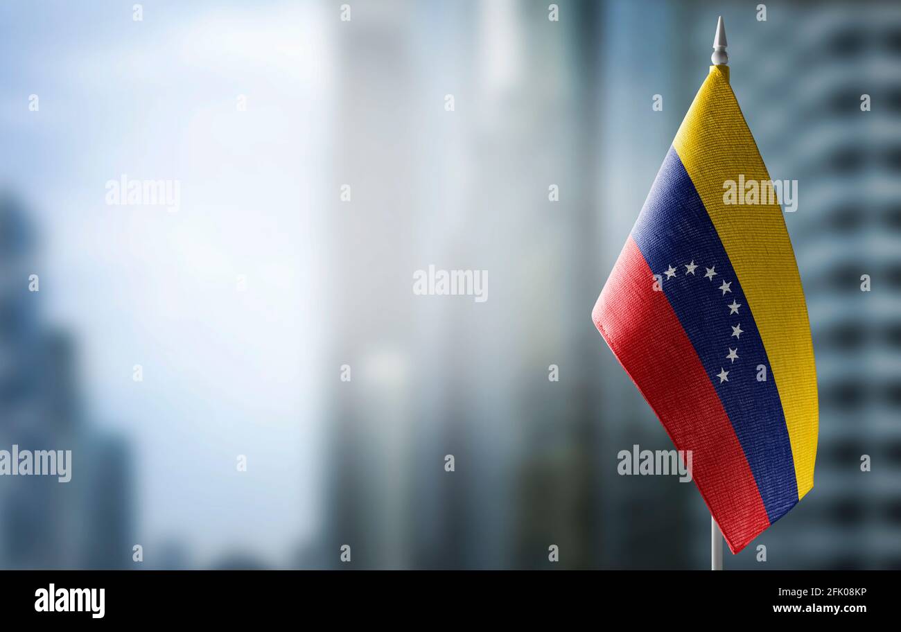 A small flag of Venezuela on the background of a blurred background ...