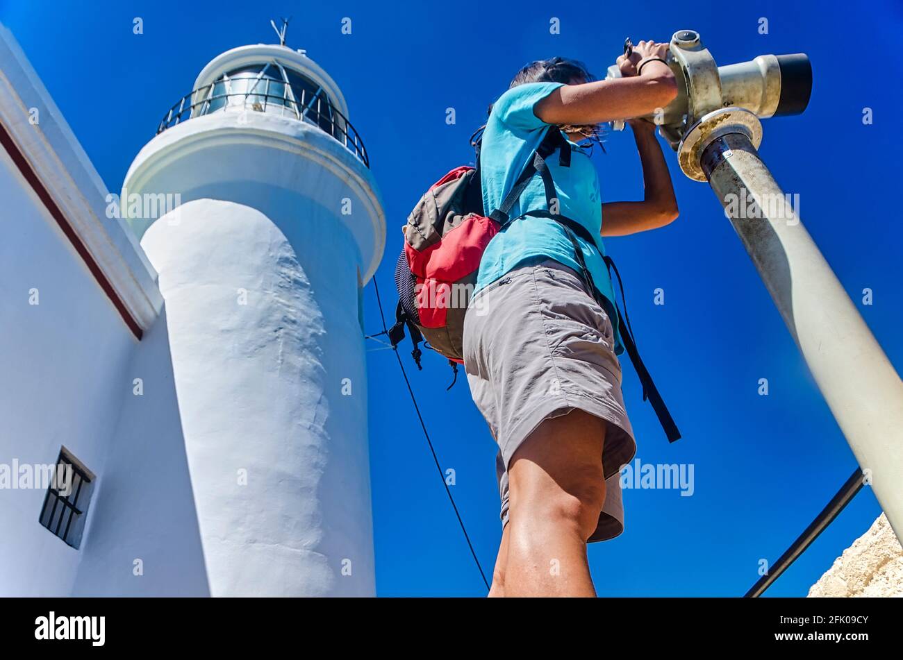 Girl using a public telescope in a white lighthouse Stock Photo - Alamy