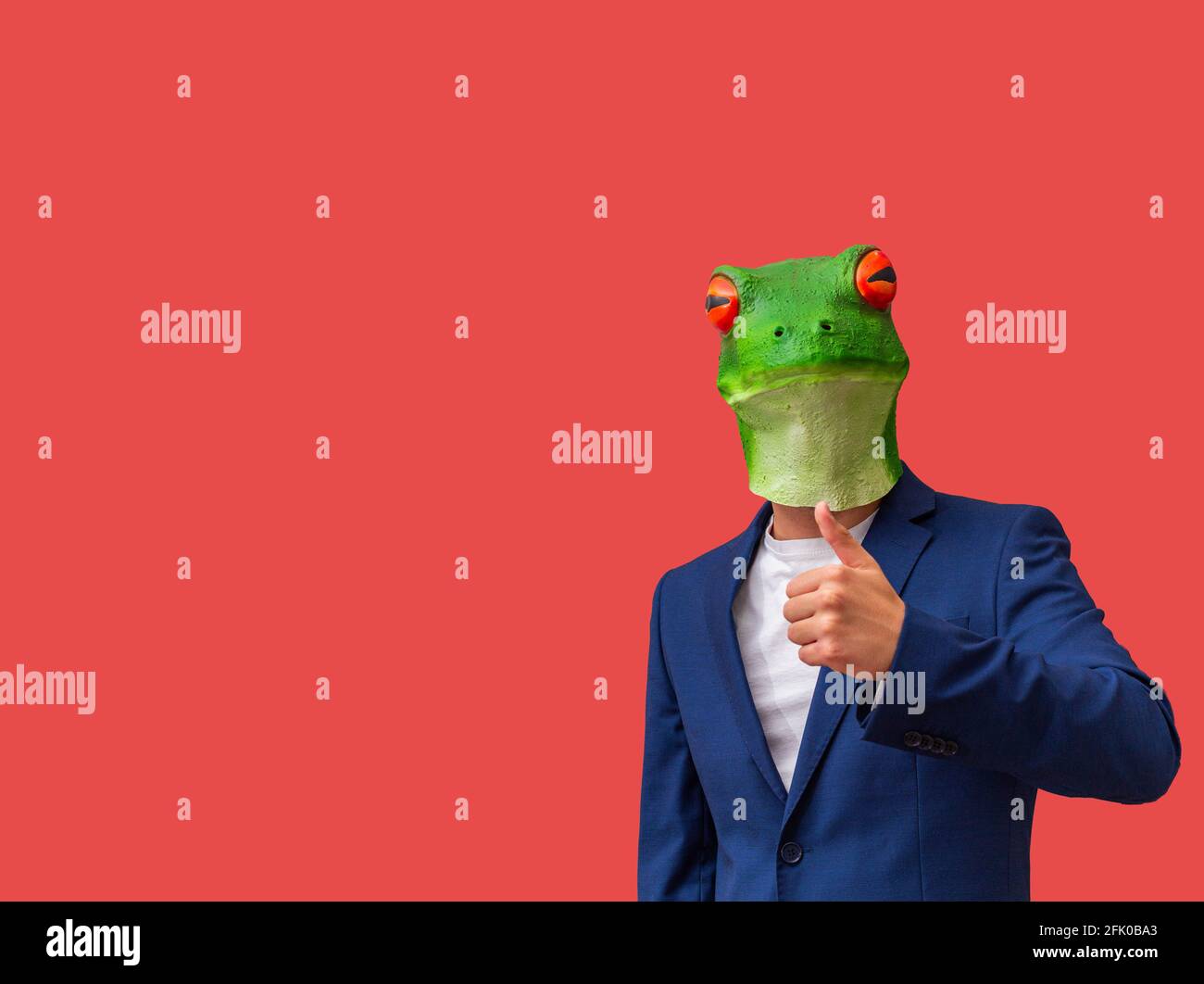 man with googly-eyed frog mask making a like or thumbs-up on red ...