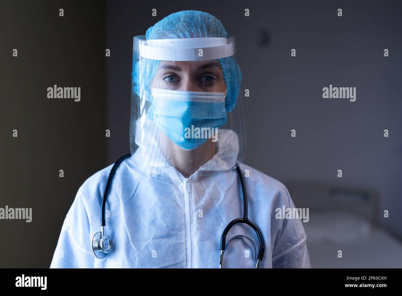 Caucasian female doctor in hospital wearing ppe suit, face mask, face ...