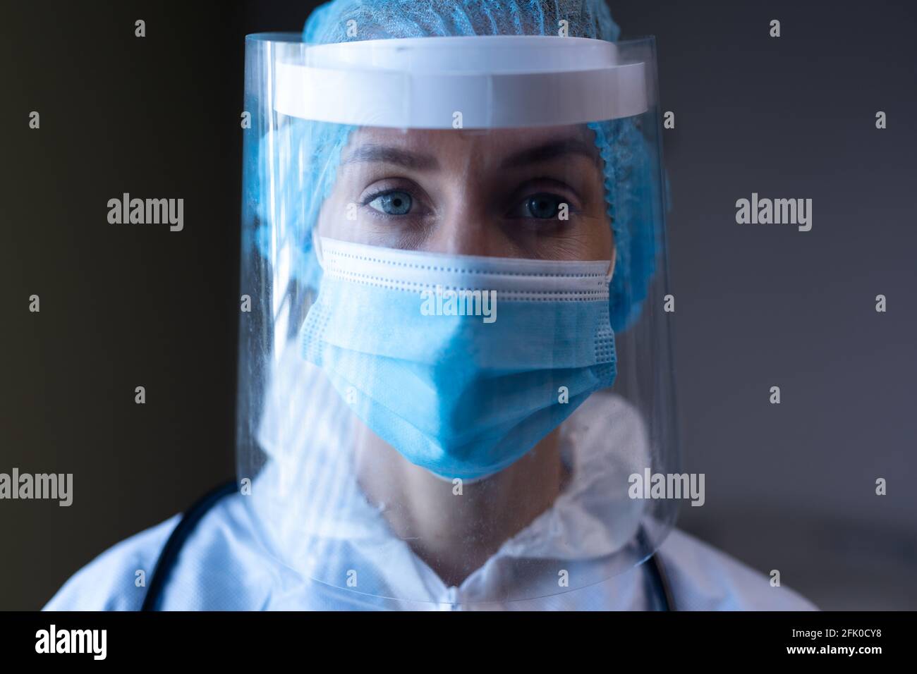 Caucasian female doctor in hospital wearing ppe suit, face mask, face ...