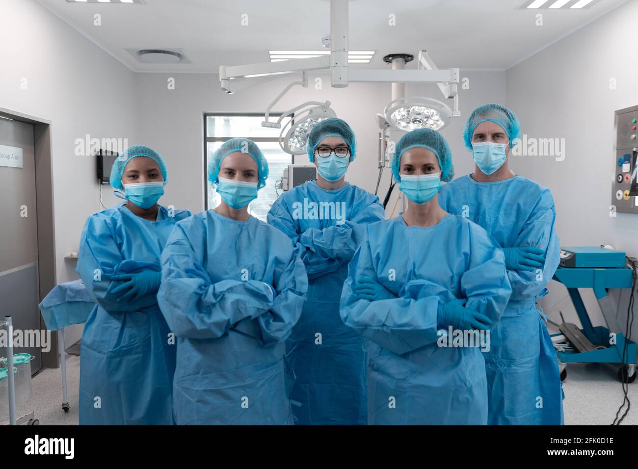 Diverse group of male and female surgeons standing in operating theatre ...