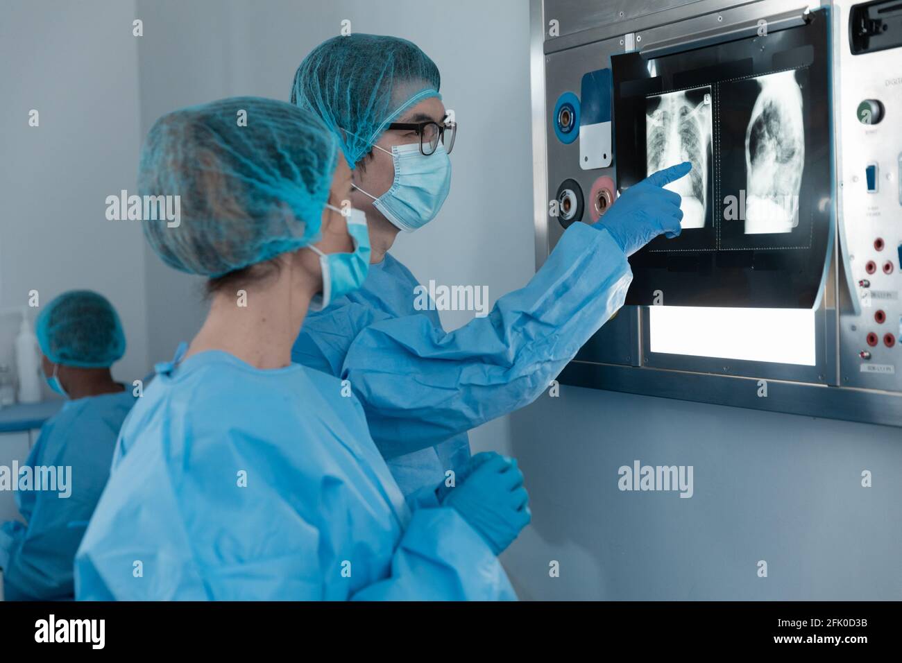 Diverse couple of male and female surgeons in operating theatre wearing ...