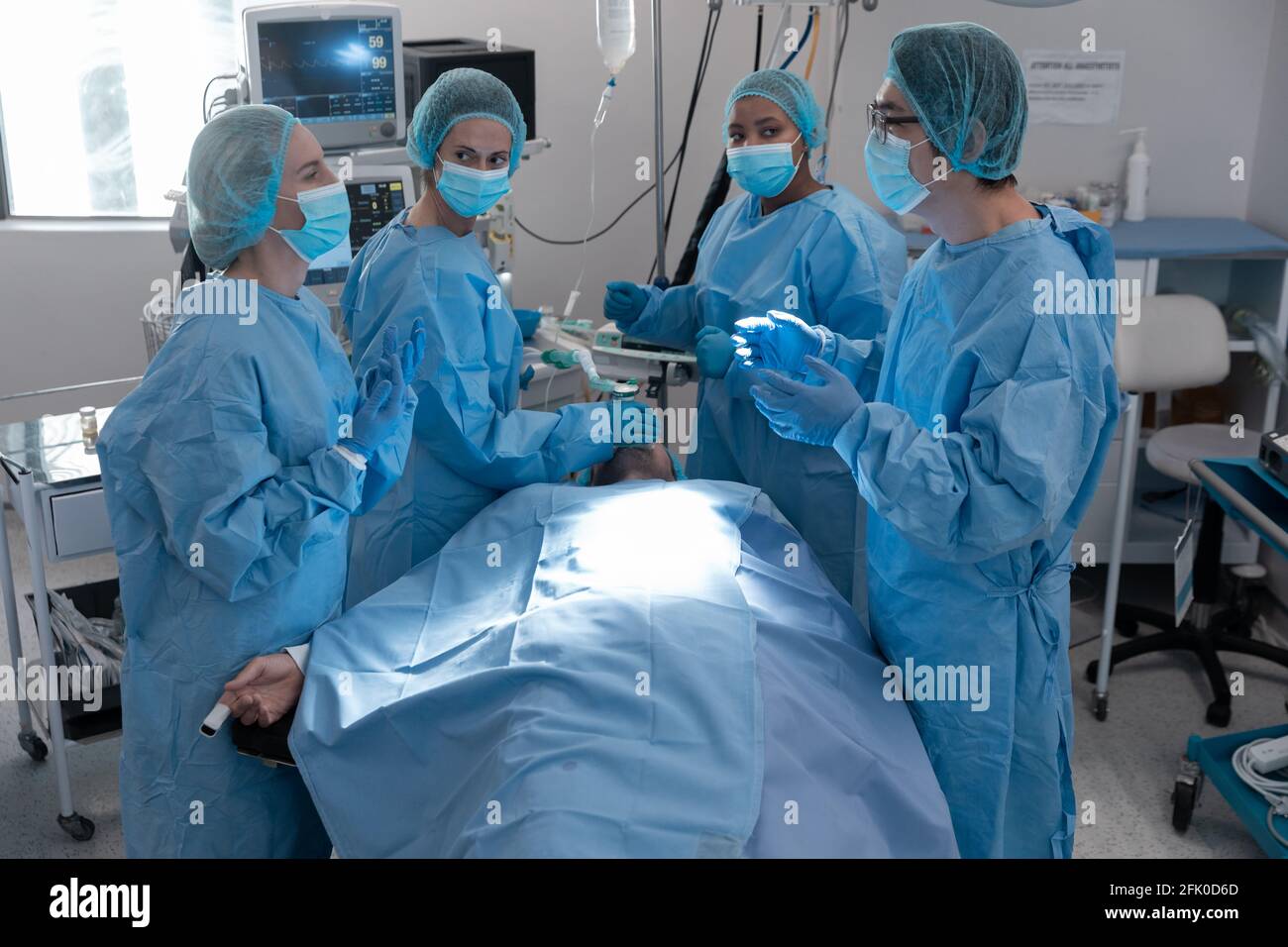 Diverse group of male and female surgeons in operating theatre wearing ...