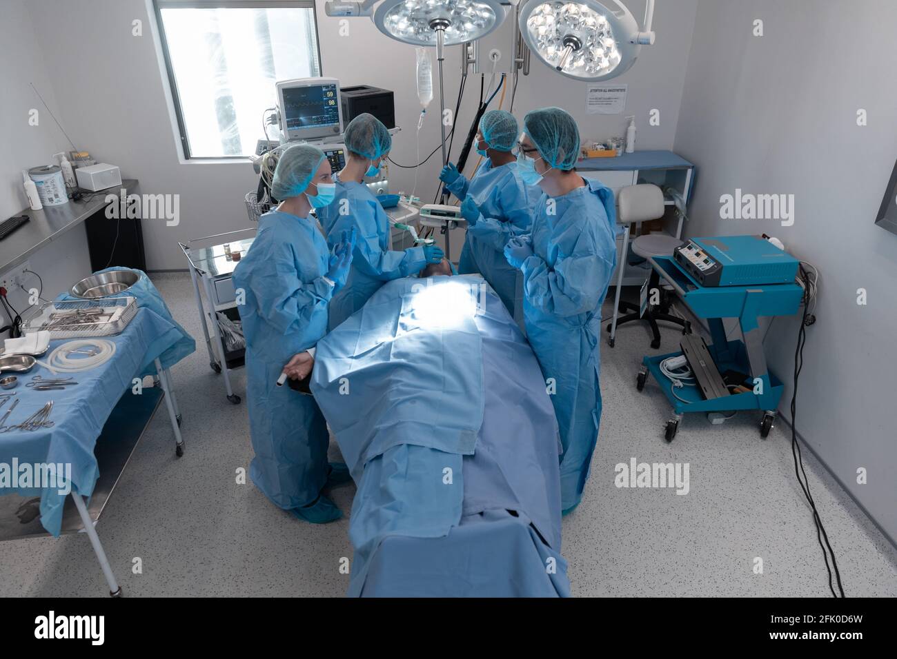 Diverse group of male and female surgeons in operating theatre wearing ...