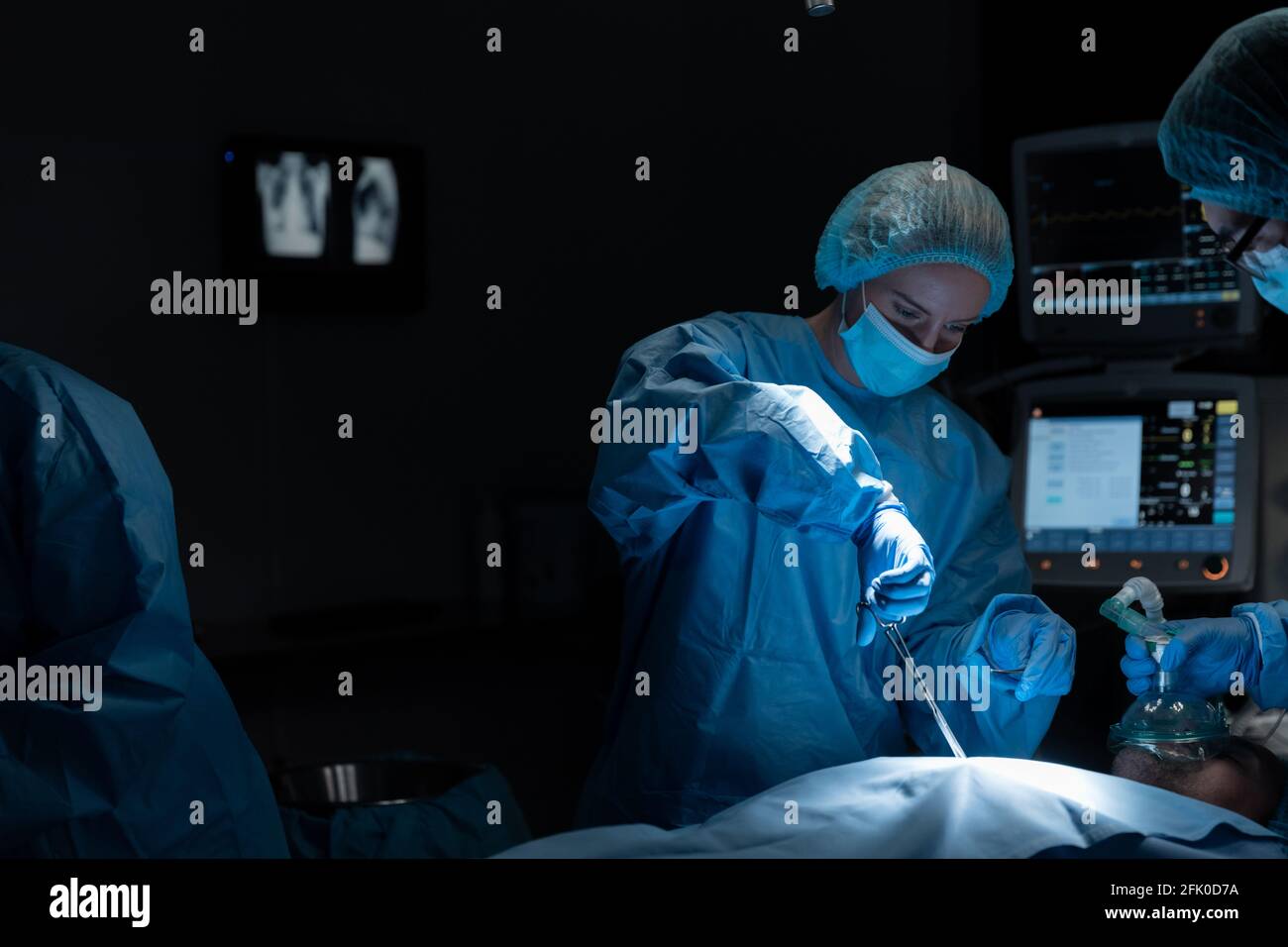 Diverse group of male and female surgeons in operating theatre wearing ...