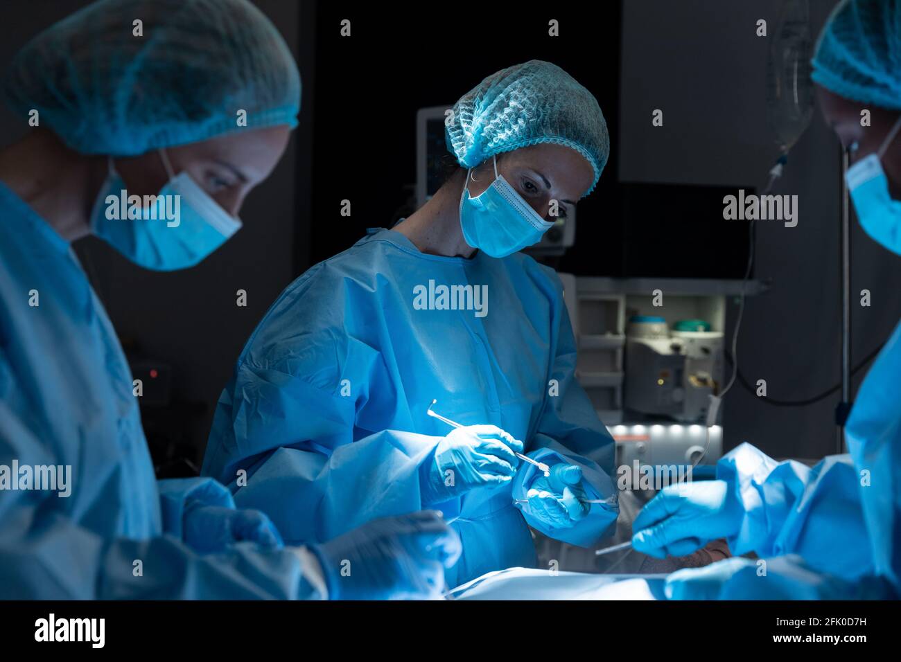 Diverse group of male and female surgeons in operating theatre wearing ...