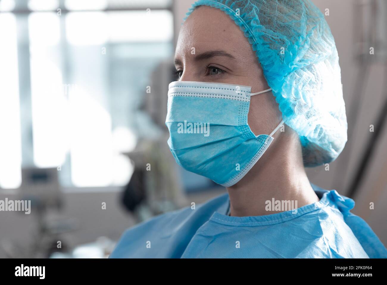 Portrait of caucasian female surgeon standing in operating theatre ...