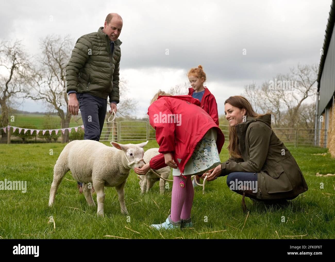 The Duke and Duchess of Cambridge strokes lambs with farmers daughters Clover 9, and Penelope ...
