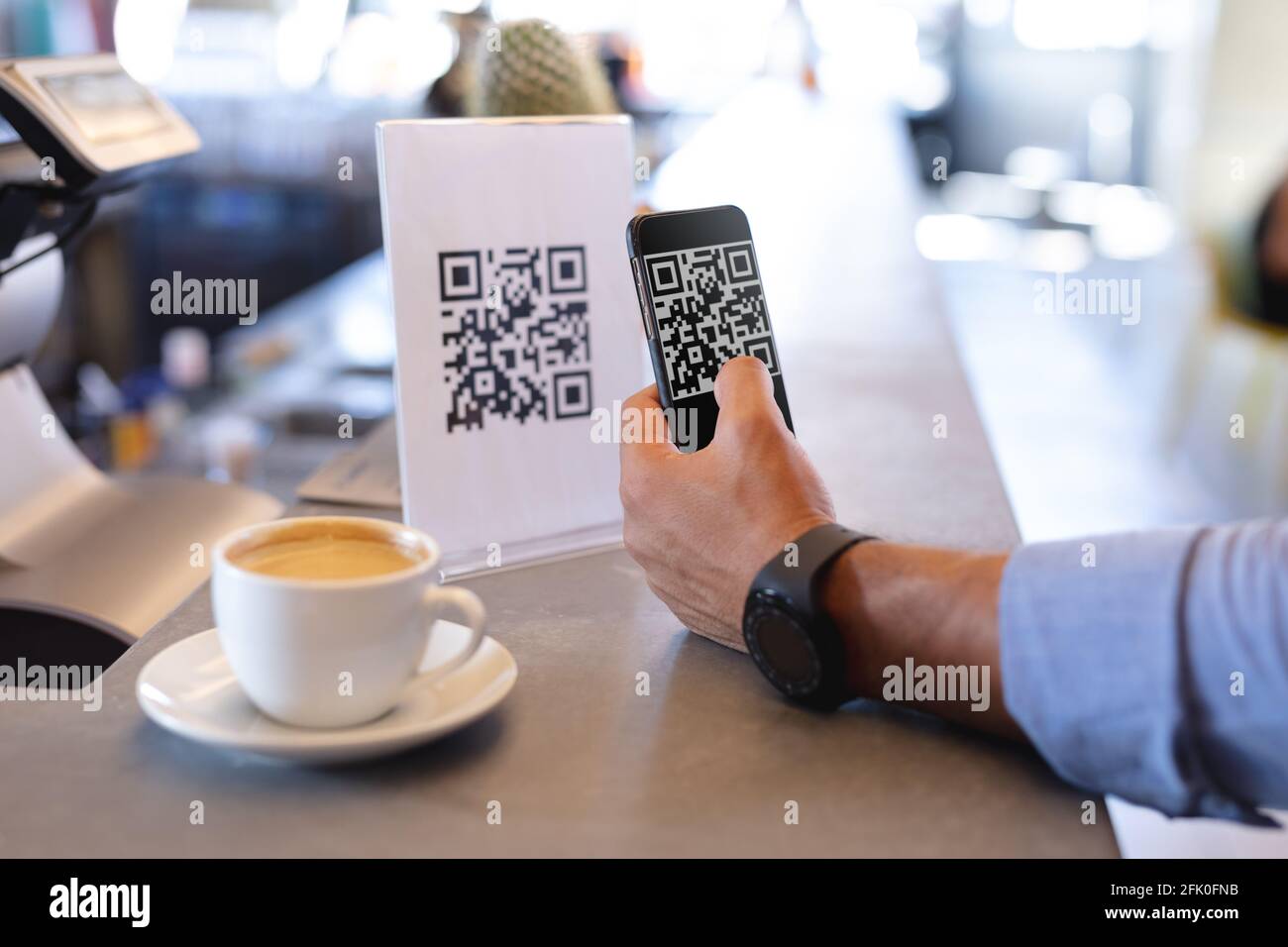 Mixed race man using smartphone and reading qr code in cafe Stock Photo ...