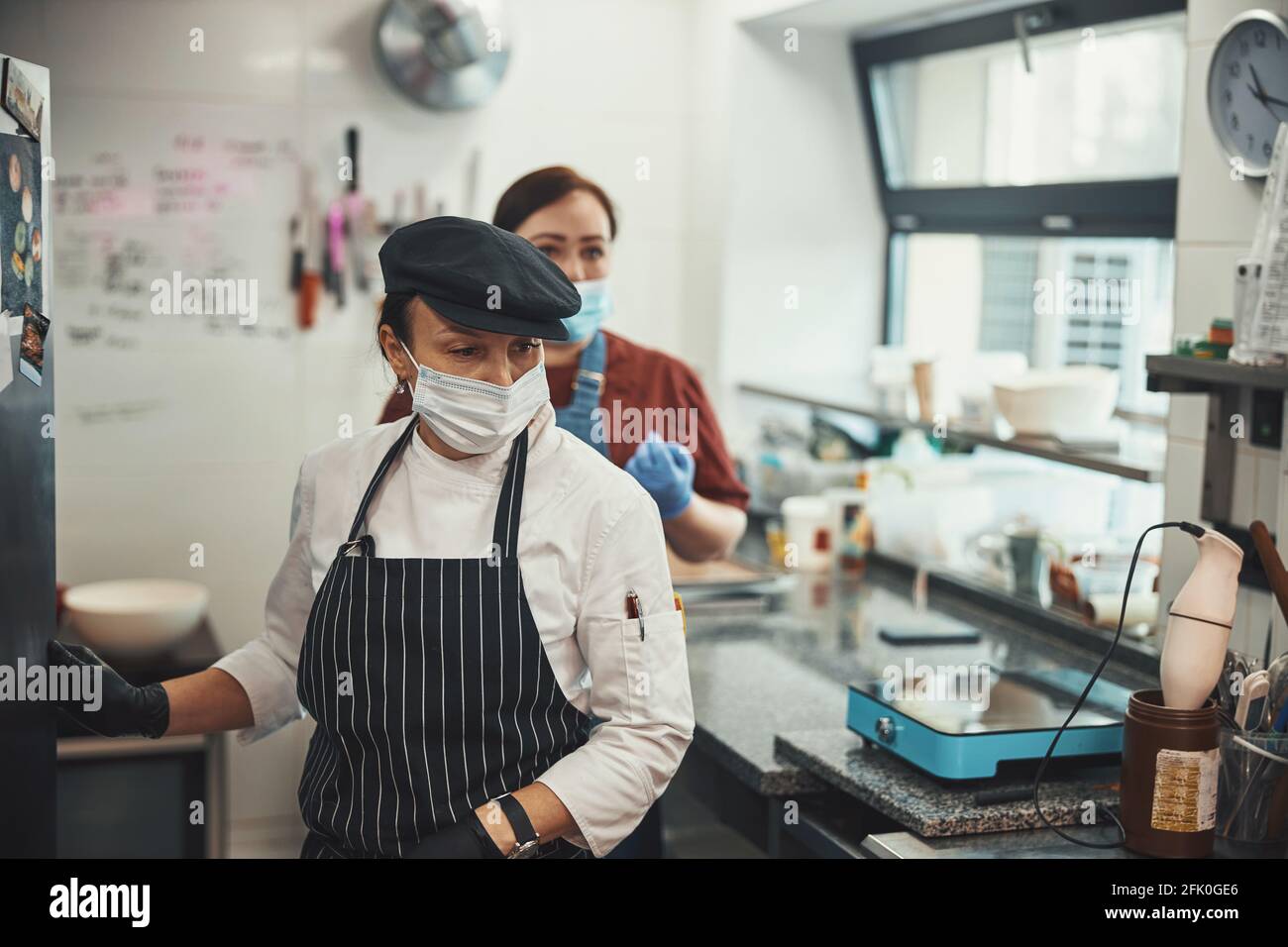 Professional chefs in masks and gloves working in kitchen Stock Photo ...