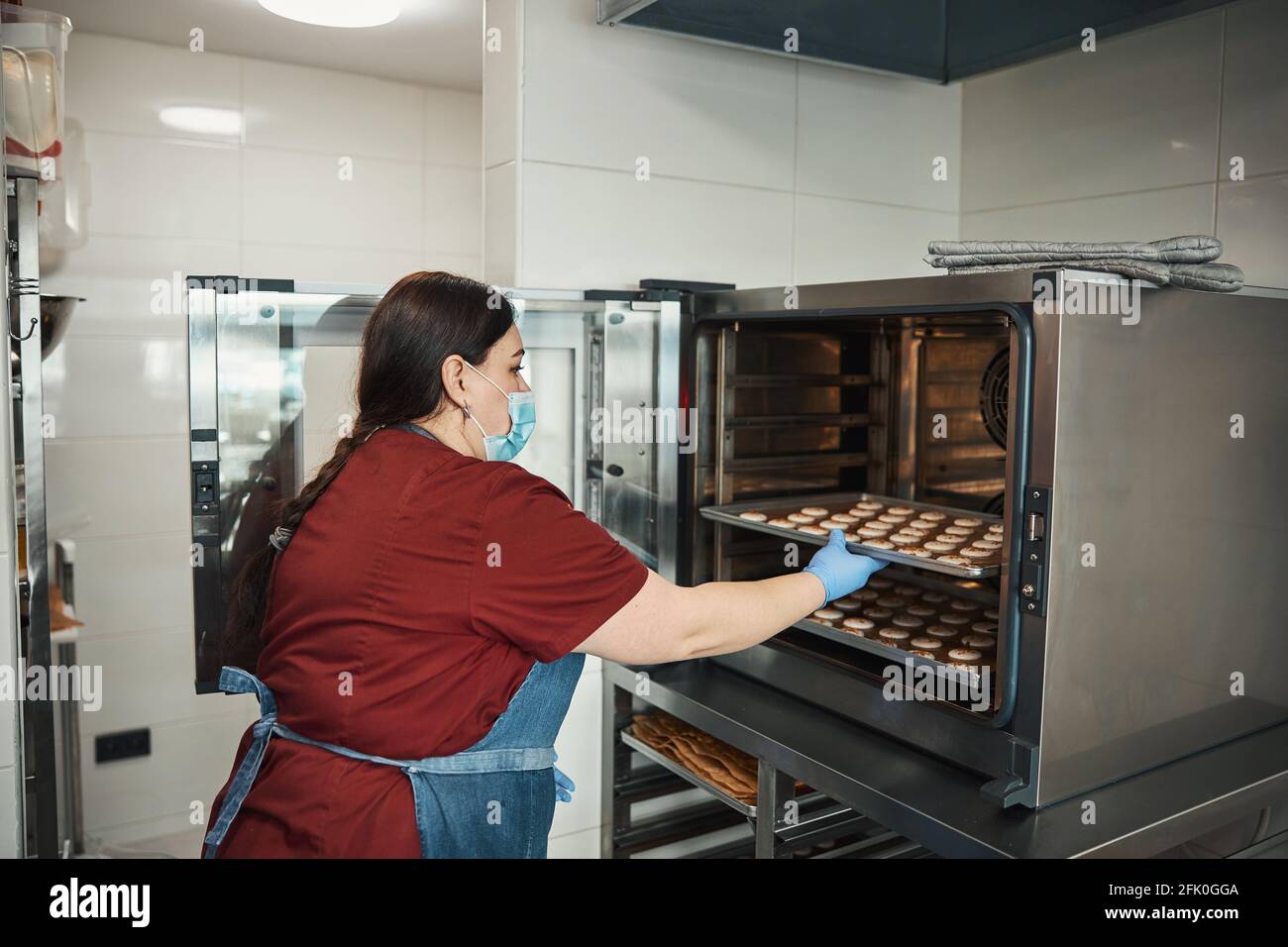 Kitchen staff being in charge of baking macarons Stock Photo - Alamy