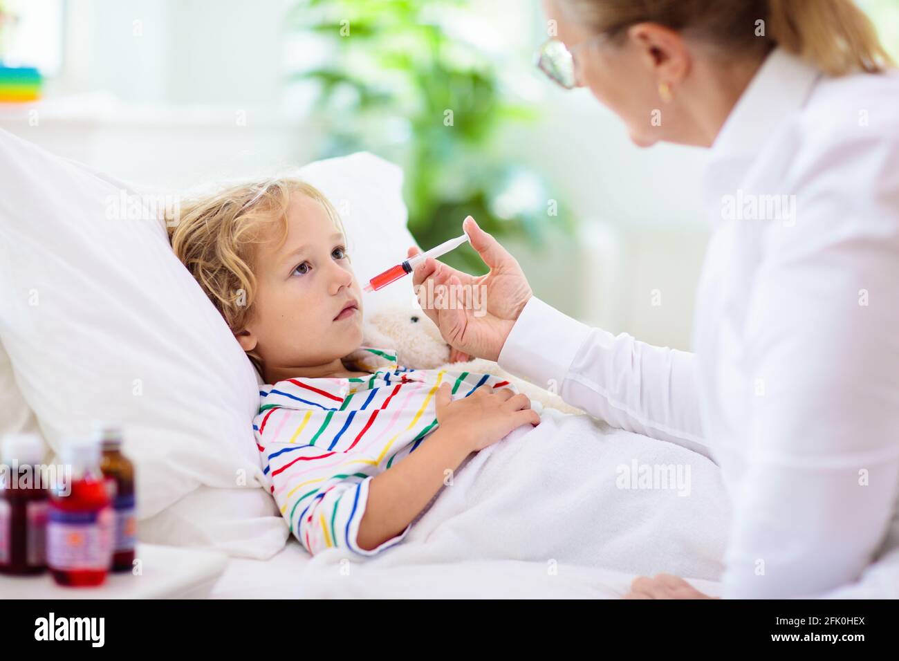 Sick little boy with medicine. Mother checking fever of ill child in ...