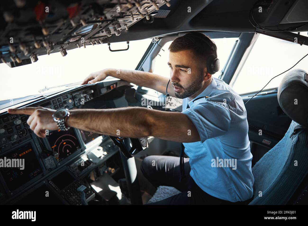 Worried young pilot pointing to something outside the aircraft Stock ...