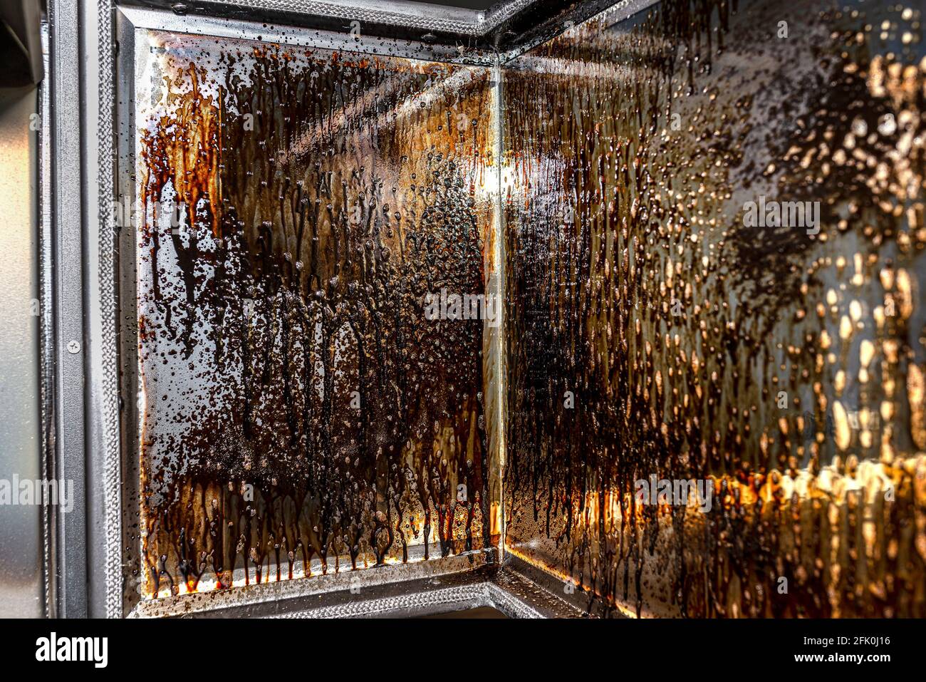 Cleaning the corner glass from soot in a modern fireplace with a closed ...