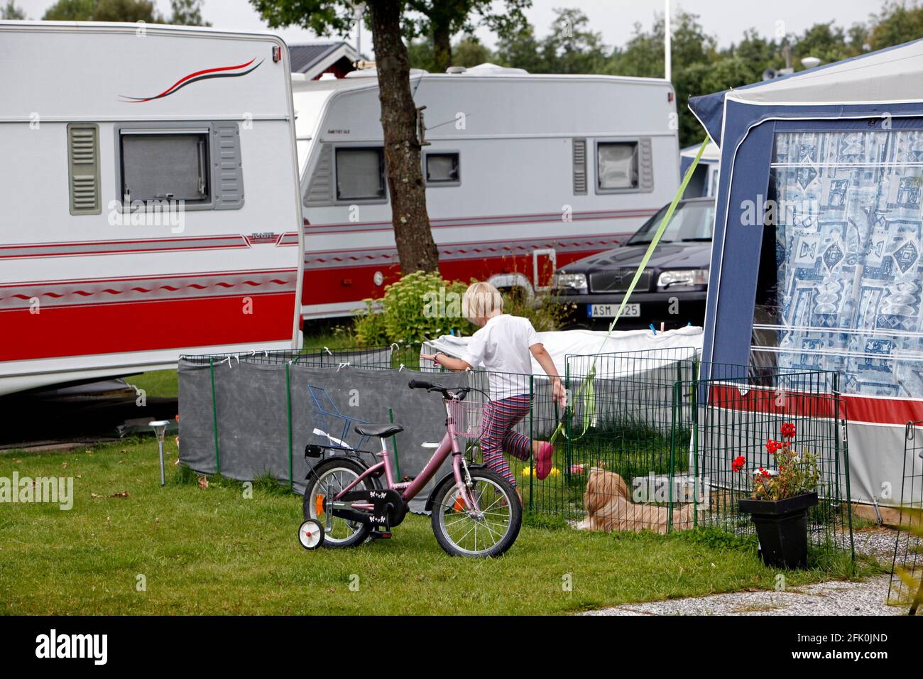 A small child playing next to the caravan on a campsite Stock Photo - Alamy