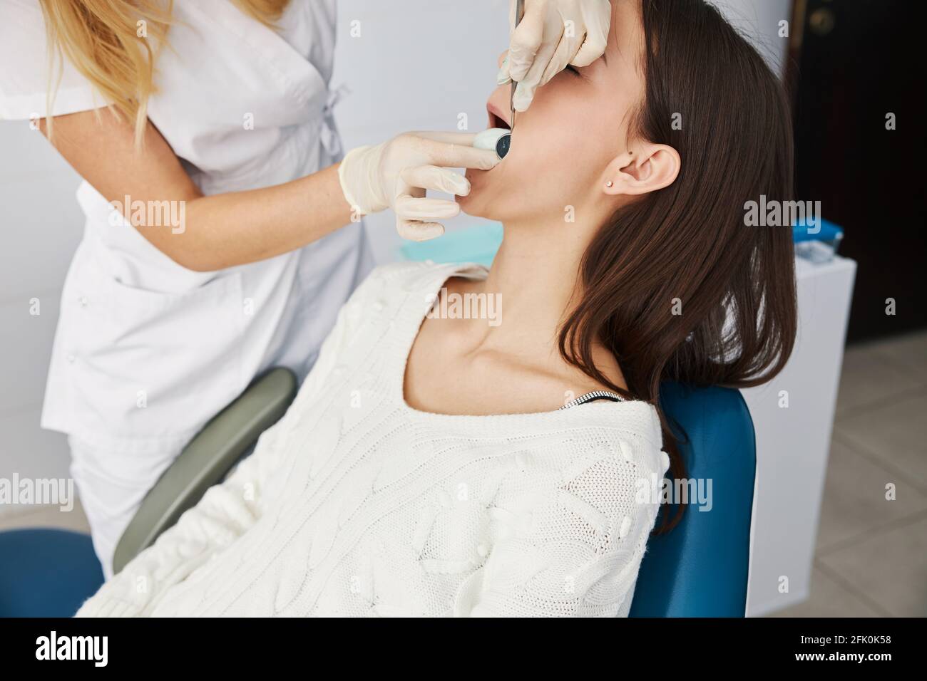 Dental worker placing plaster stone into female patient mouth Stock ...