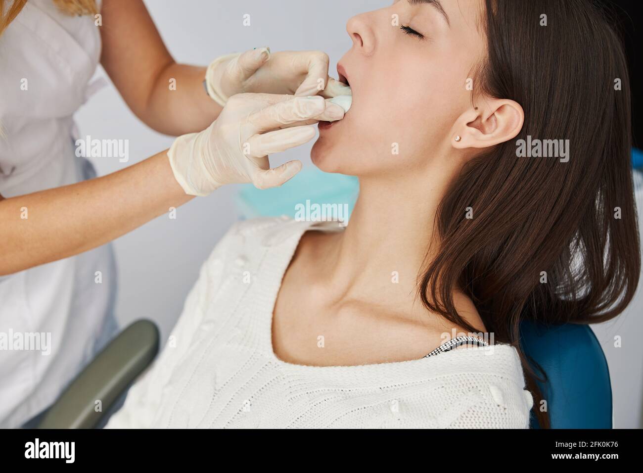 Dentist adjusting jaw cast putty lying on female tongue Stock Photo - Alamy