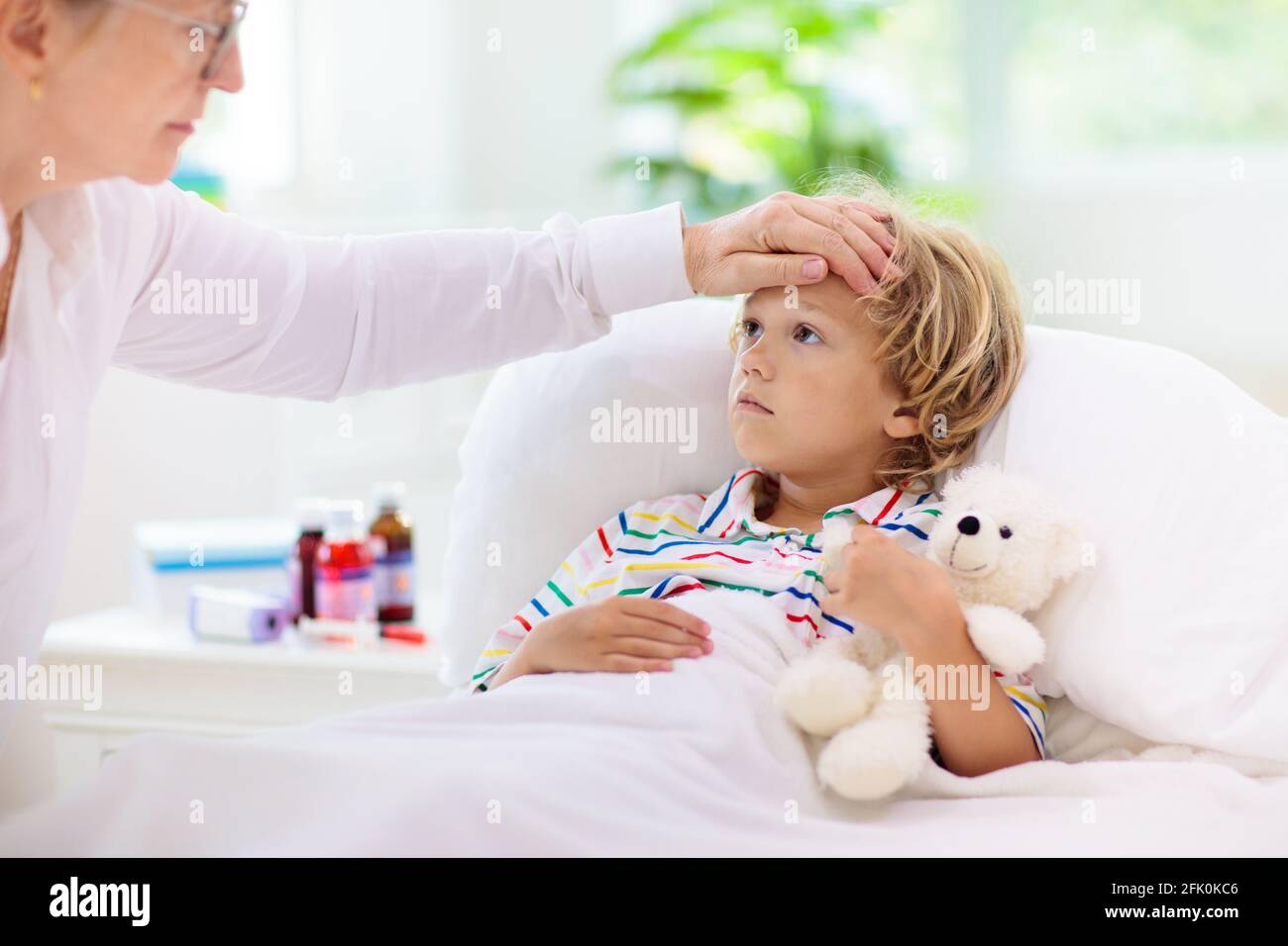 Sick little boy with medicine. Mother checking fever of ill child in ...