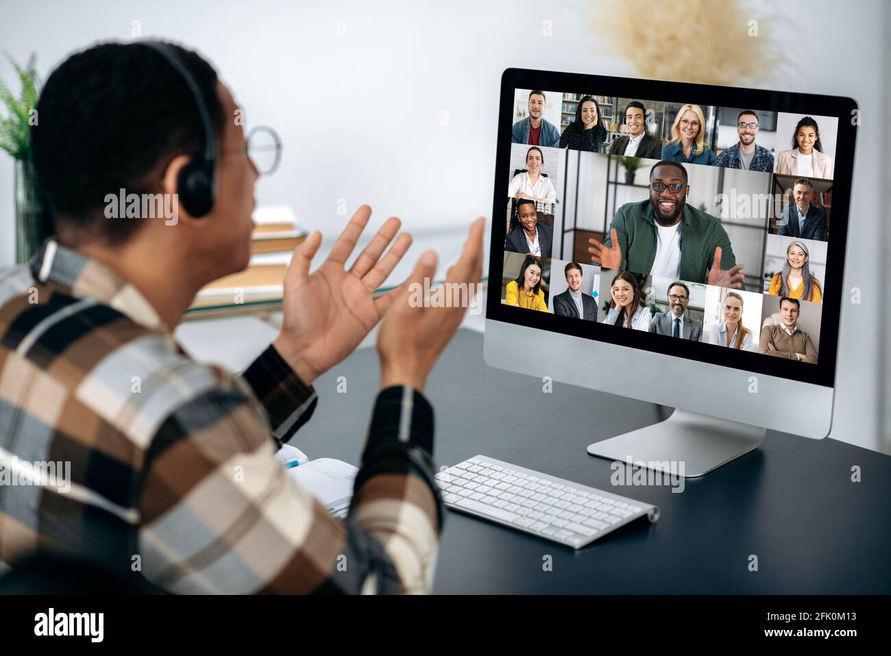 Video call, online conference. Over shoulder view of mixed race man, on ...