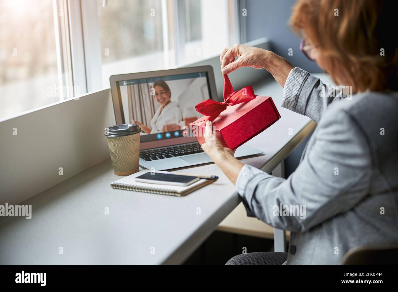 Focused photo on cute female opening her present Stock Photo - Alamy
