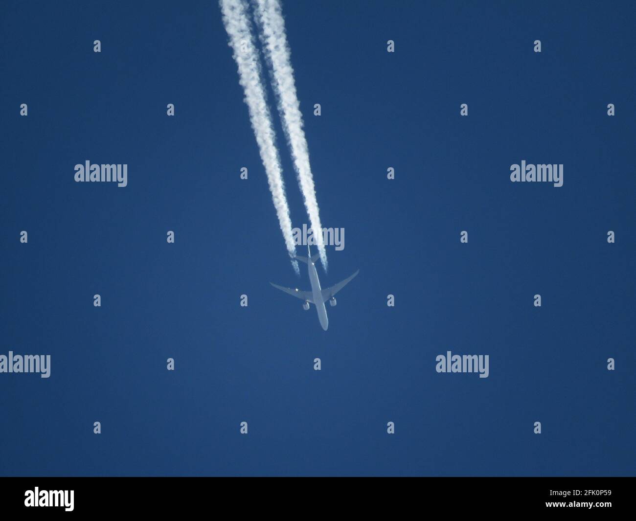 Tele close-up of an airliner flying at high altitude in a clear blue ...
