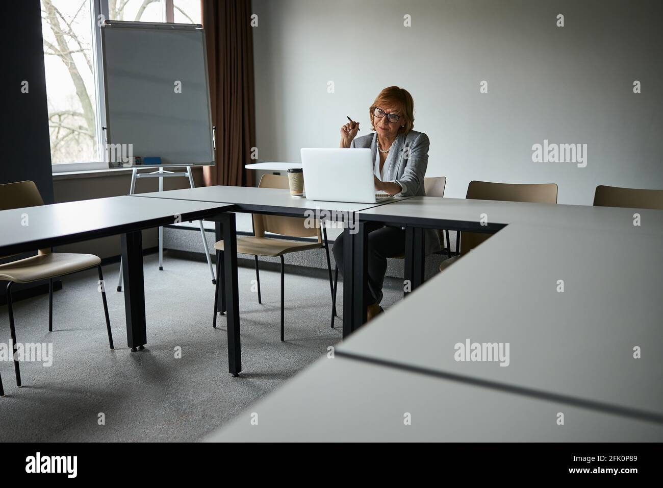 Attentive female sitting in the meeting room alone Stock Photo - Alamy