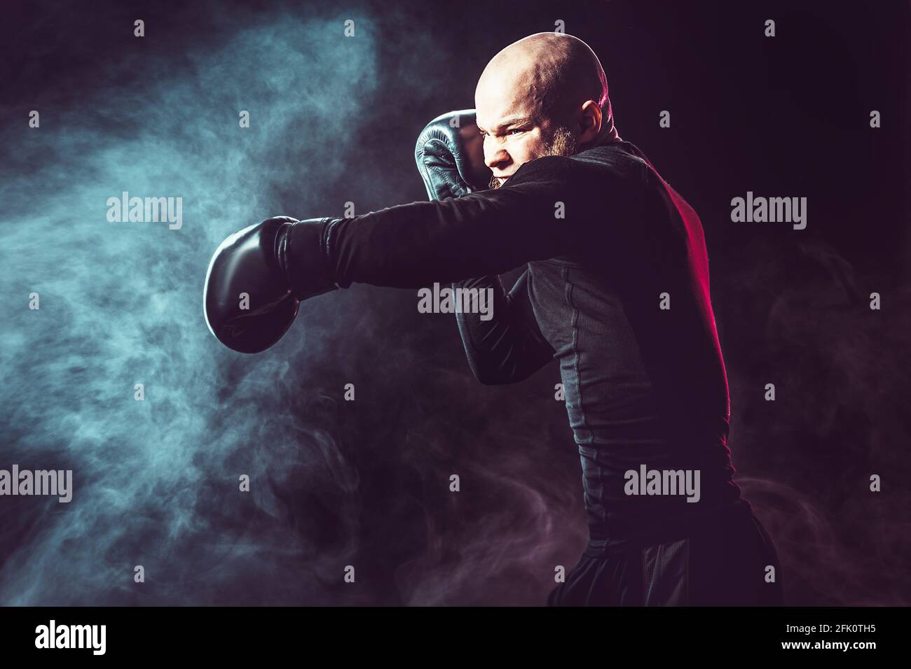 Sportsman boxer fighting on black background with smoke. Boxing Stock ...