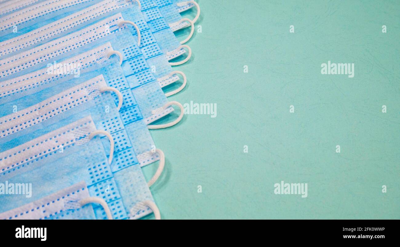 Blue medical masks on a green background. Negative space or copy space ...