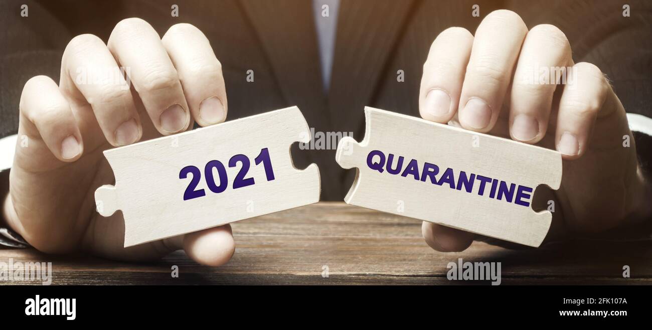 A man collects wooden puzzles with the words 2021 and Quarantine ...
