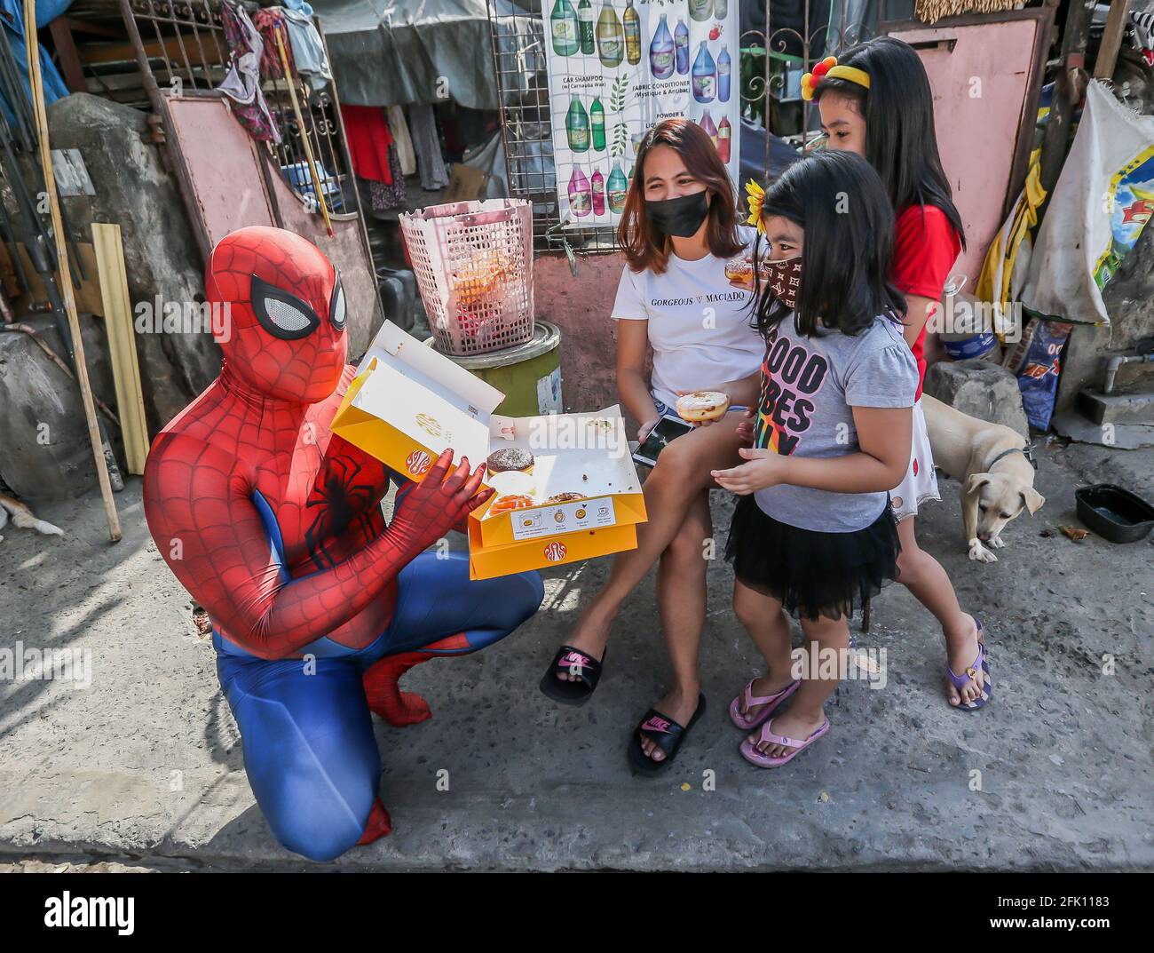 Manila. 27th Apr, 2021. A man dressed as Spider-Man distributes donuts ...