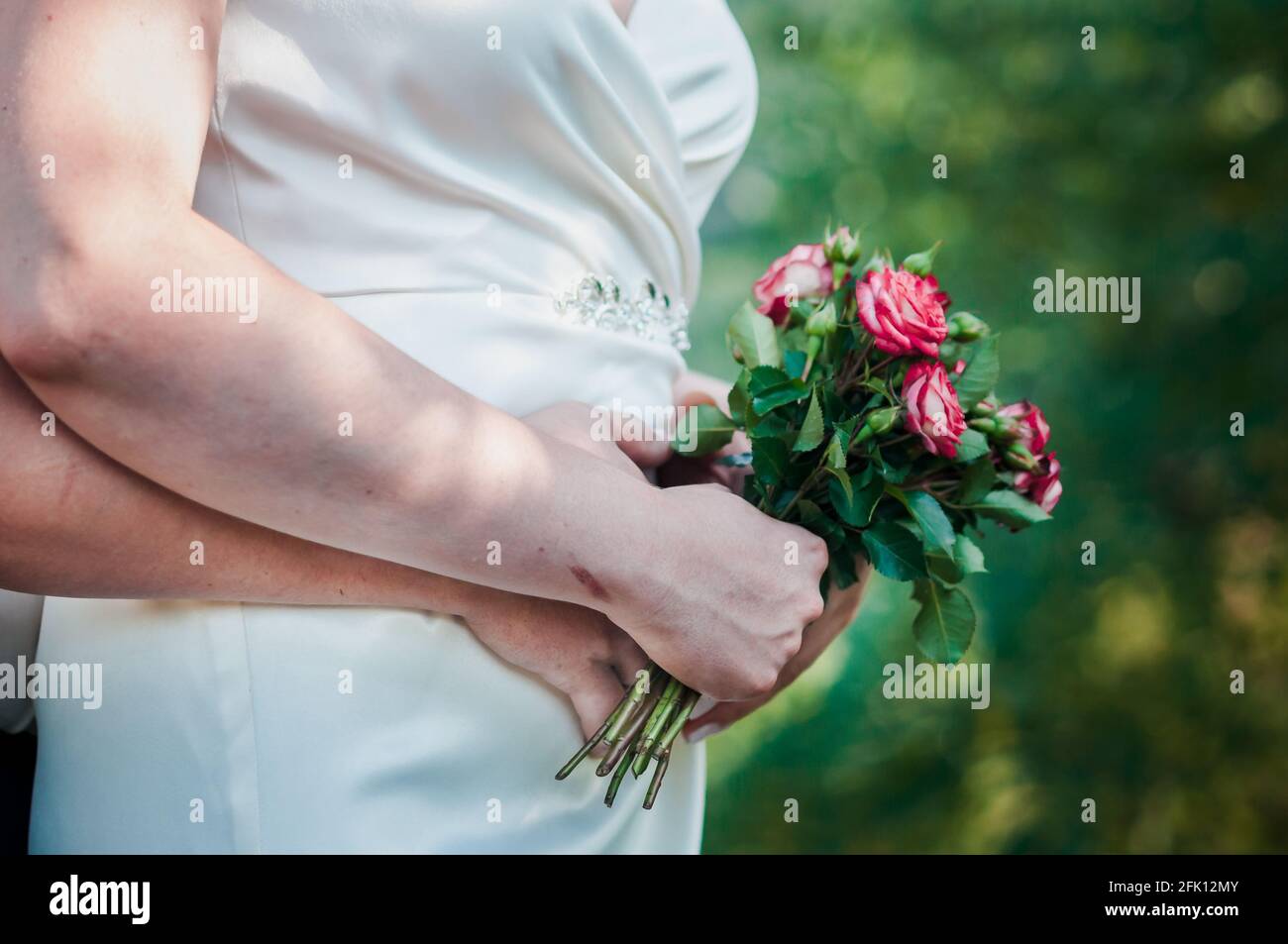 Bouquet with pink roses in the hands of a girl Stock Photo - Alamy
