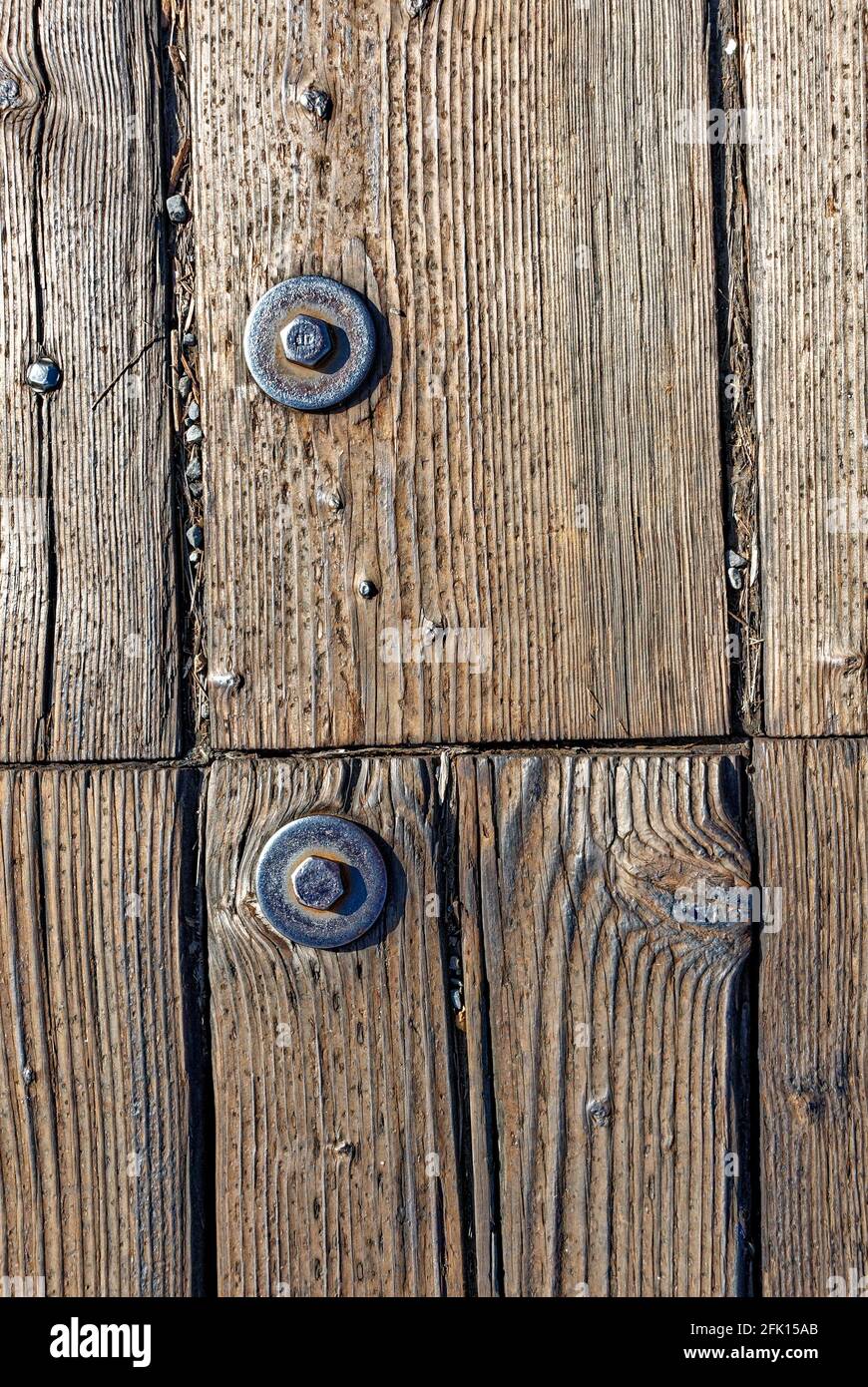Old rusty timber bolt inside a wooden floor of what used to be a pier ...
