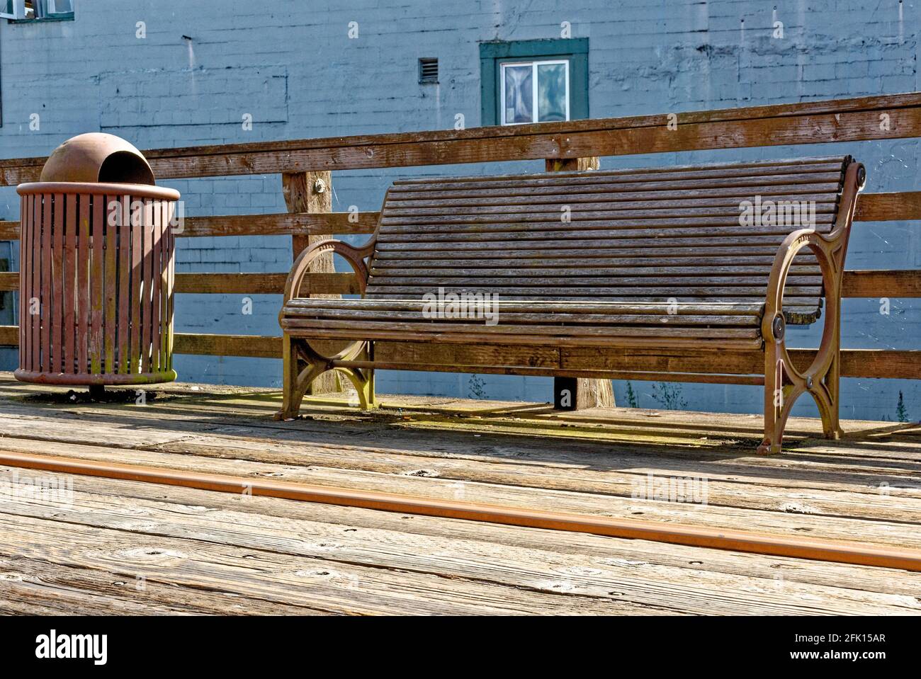 Old rustic vintage bench and rusty trash bin on a pier in Astoria ...