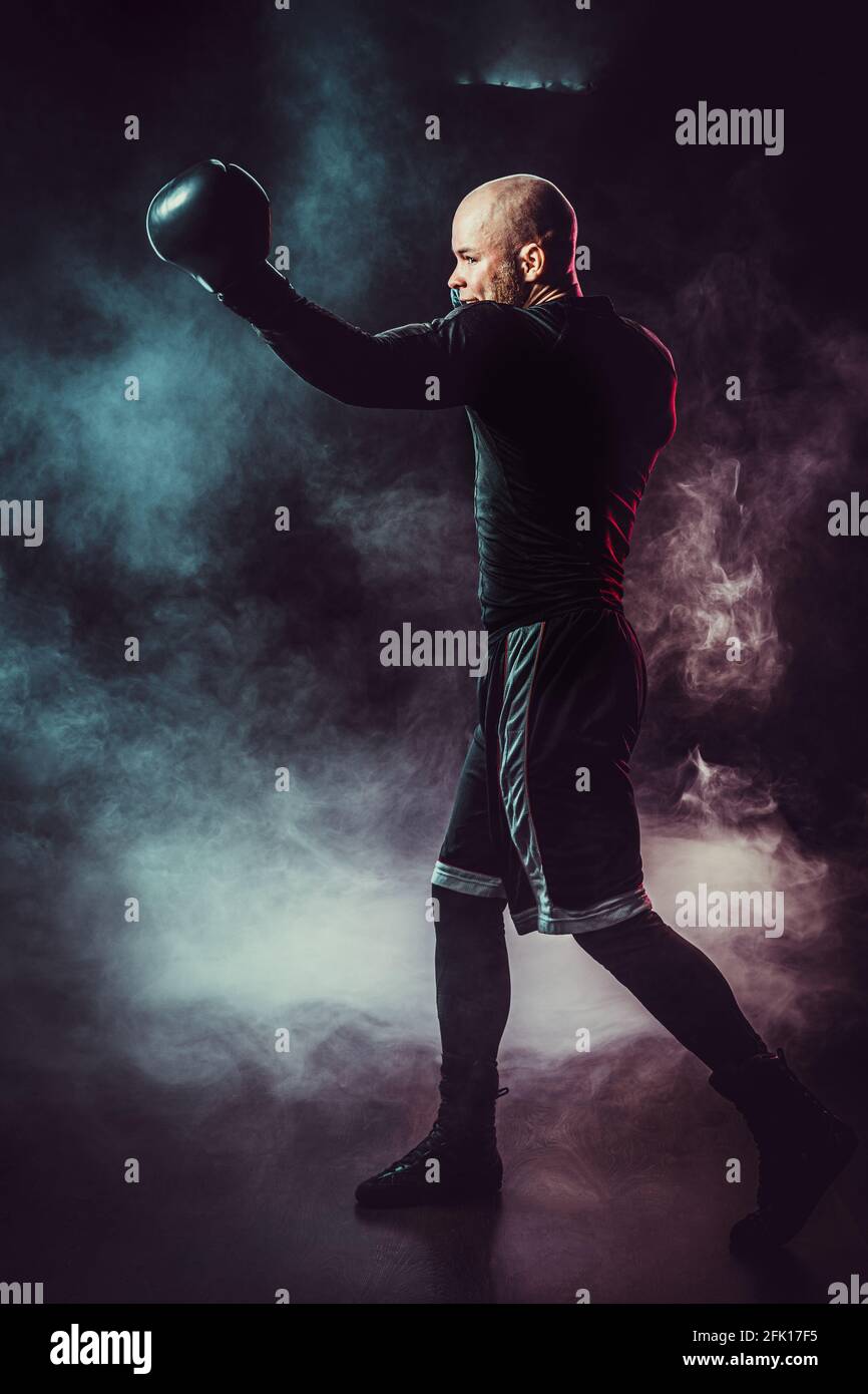 Sportsman boxer fighting on black background with smoke. Boxing Stock ...