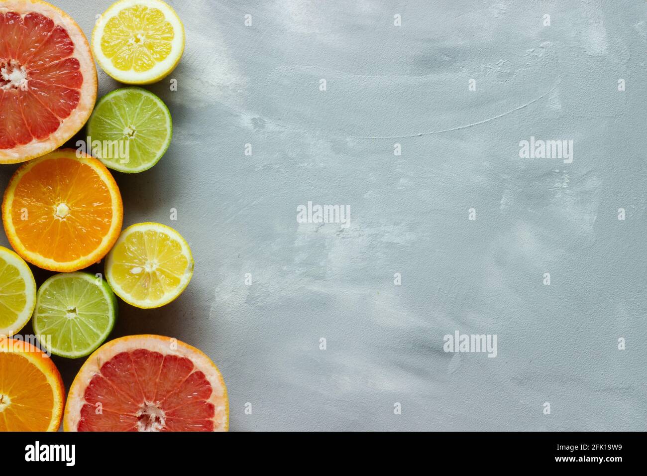 Colorful and tropical citrus fruits on gray background with copy space ...