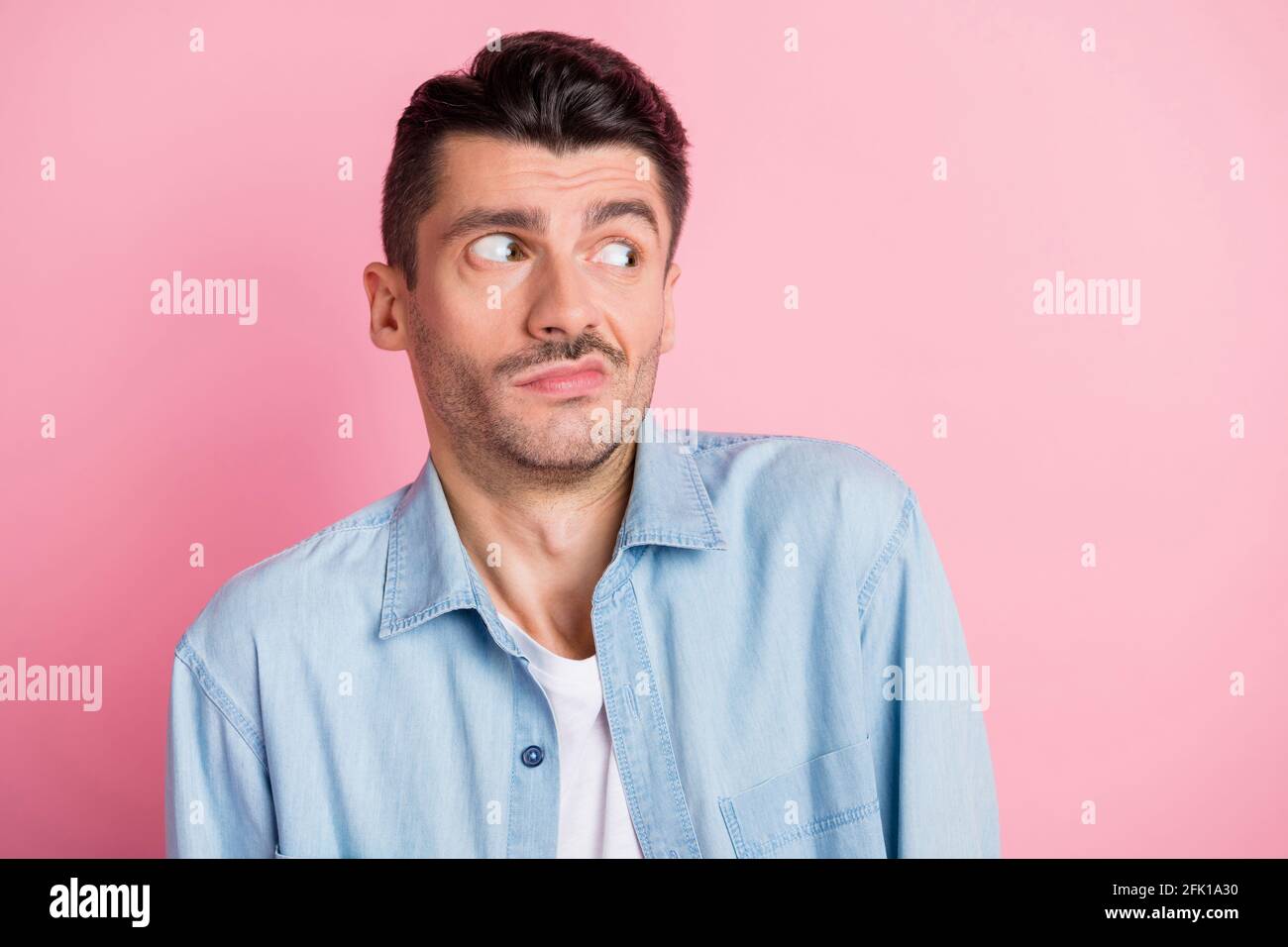 Photo of confused brunette handsome young man wear blue shirt isolated ...