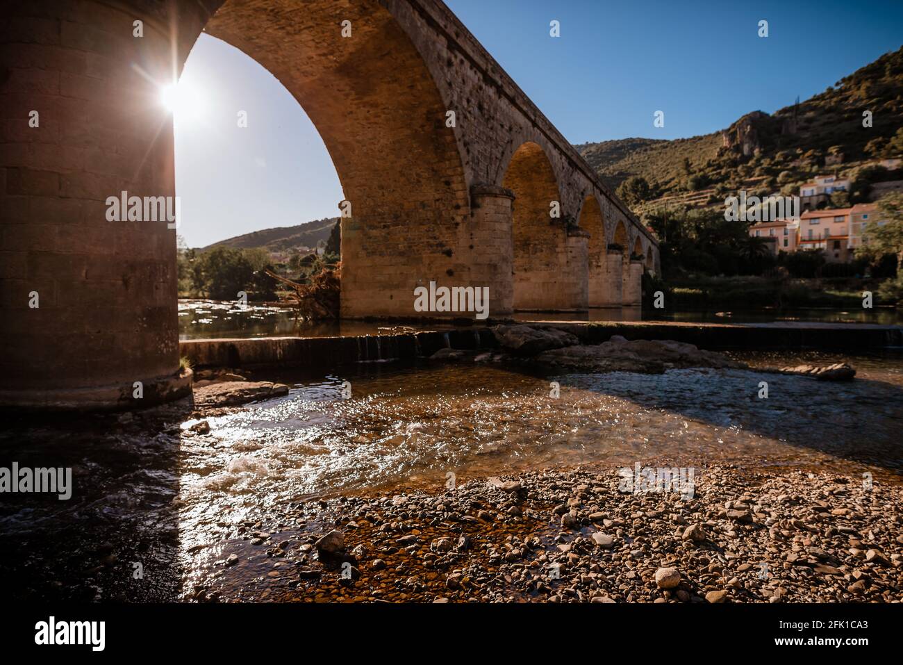 Old stone arch bridge across river in Mediterranean French village ...