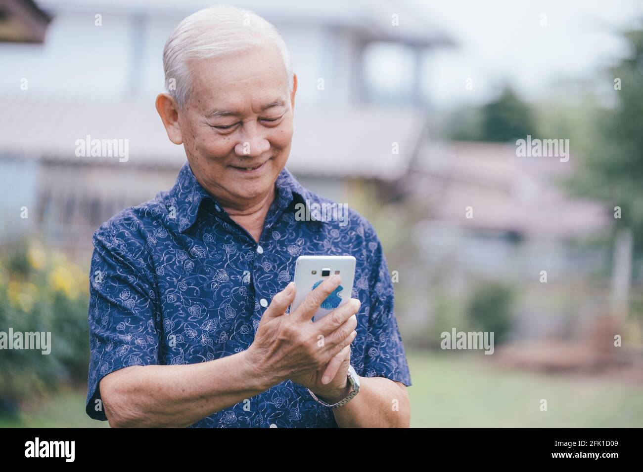 Happy asian elder man using smartphone Stock Photo - Alamy