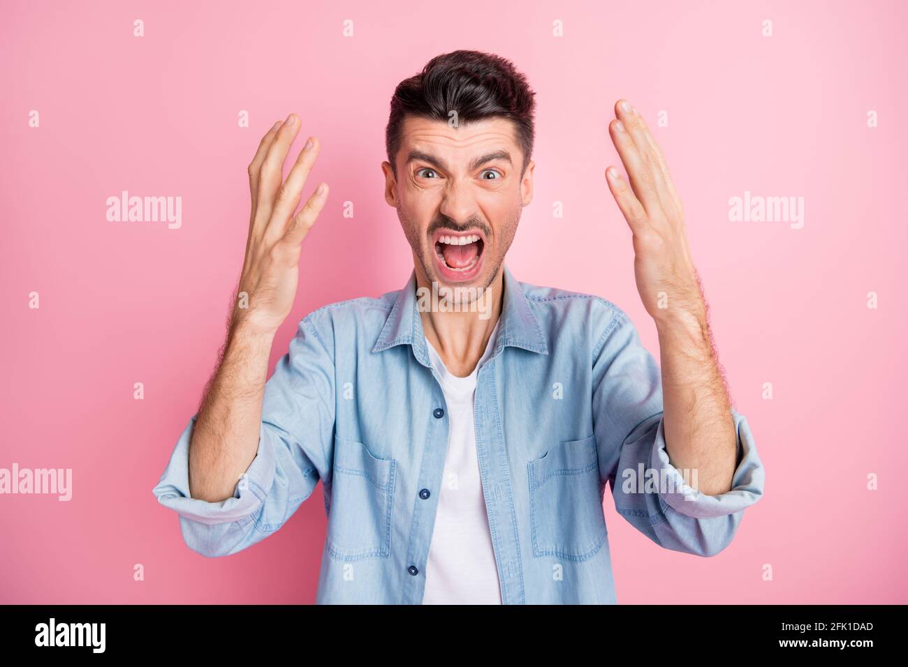 Photo of angry furious young man raise hands loud scream annoyed ...