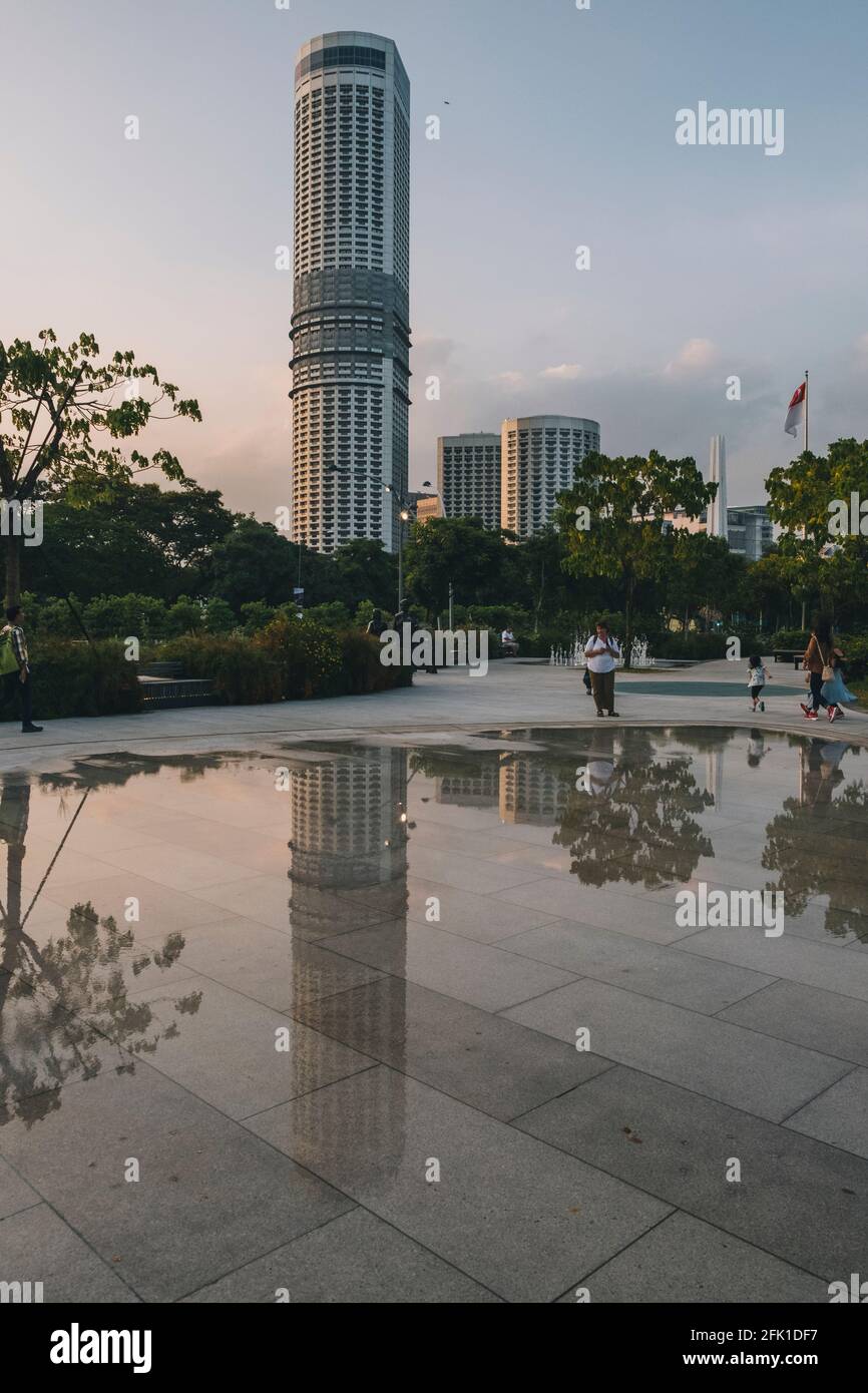 Modern round skyscraper in downtown Singapore reflected in a rain ...