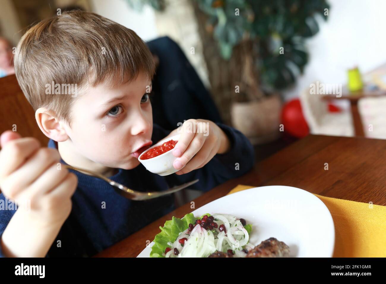 Child tasting tomato sauce in a restaurant Stock Photo - Alamy