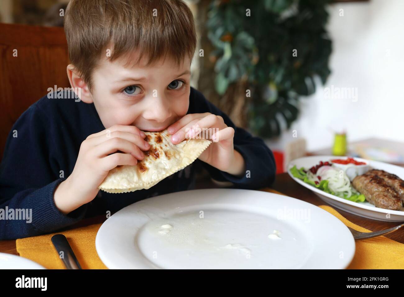Child eating cheburek in an asian restaurant Stock Photo - Alamy