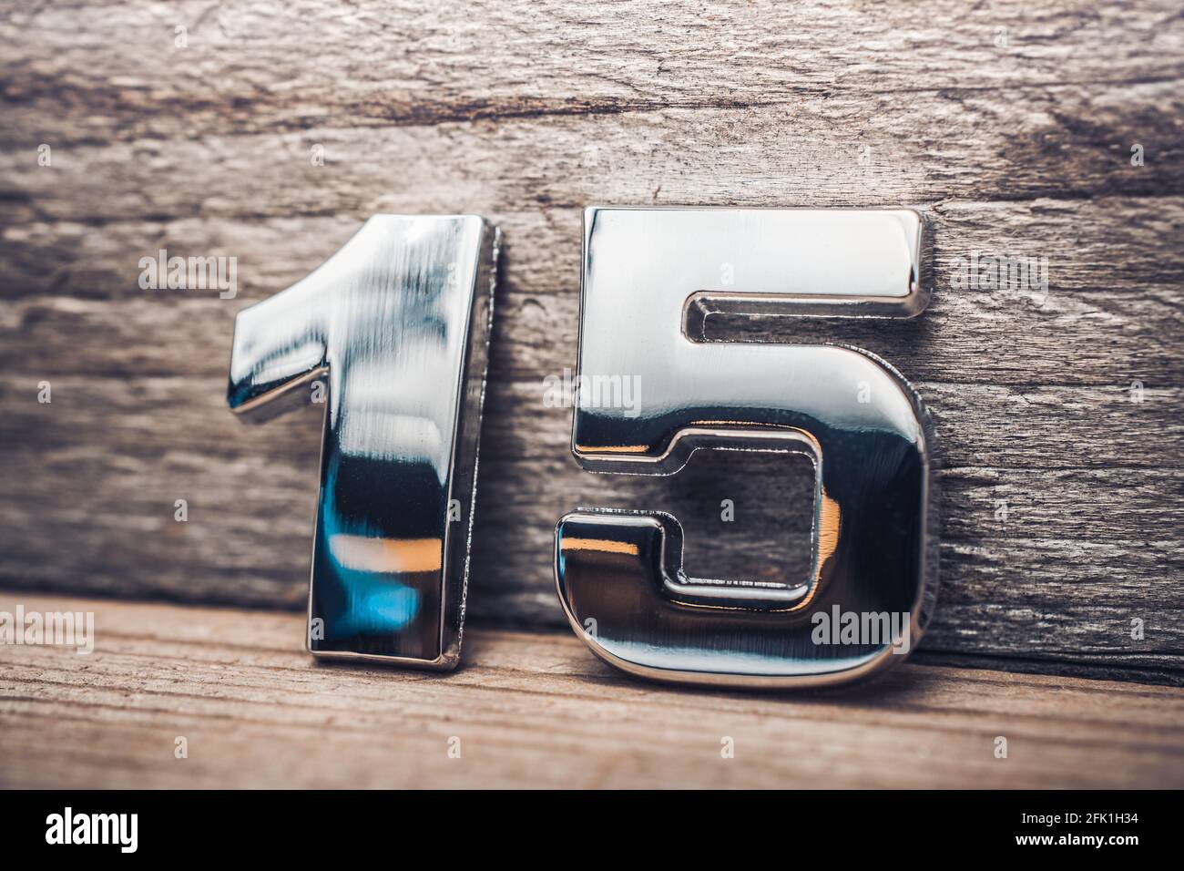 Chrome Number 15 Leaning On A Wooden Wall Stock Photo - Alamy
