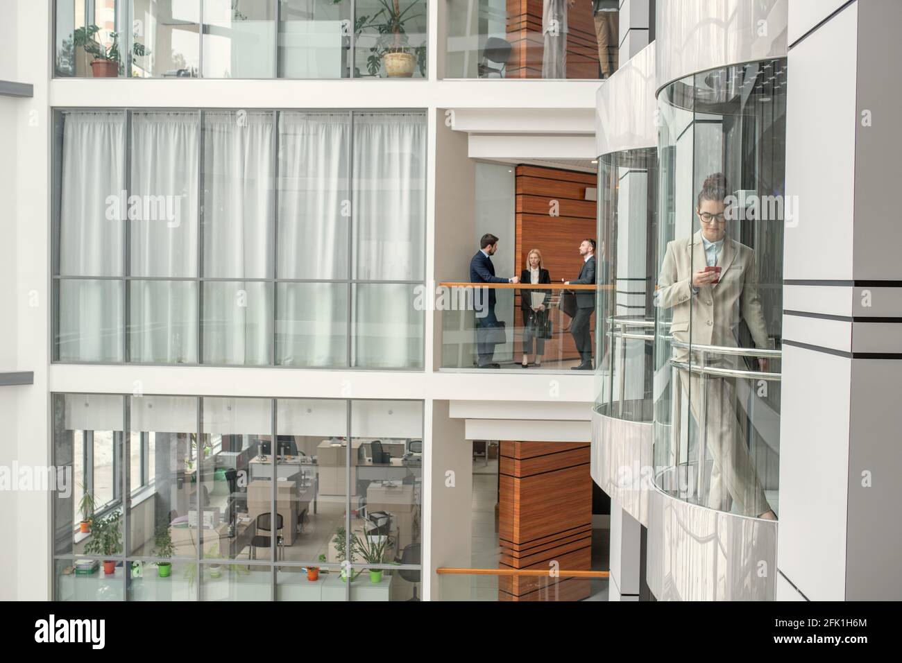 Busy people working in business hall: three colleagues discussing ...